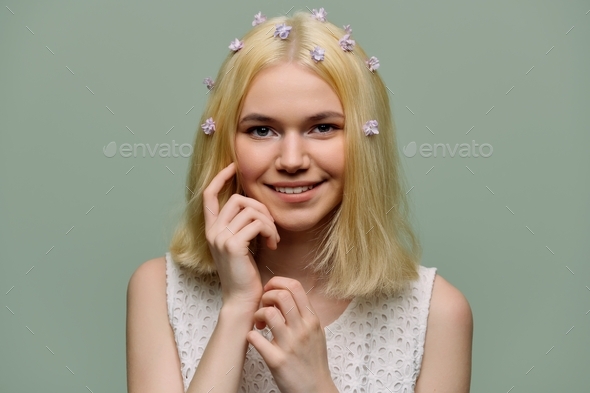 Young tender girl teenager with lilac flowers in blond hair on green ...