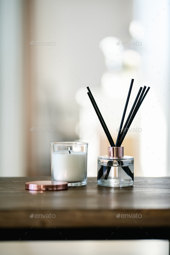 An aromatic reed diffuser stands on a table against a blurry background ...