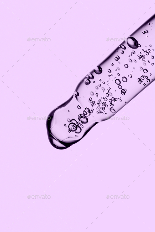 Transparent pipette with cosmetics on a purple background. Stock Photo ...