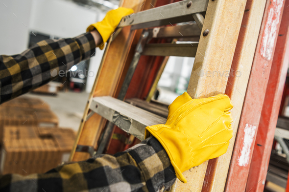 Construction Worker Moving Ladders on a Site Stock Photo by duallogic