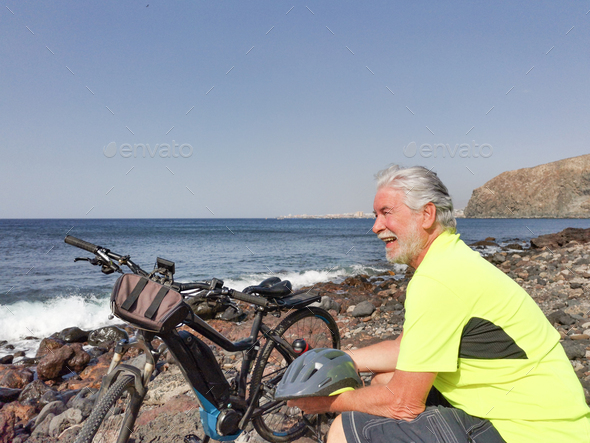 Senior cyclist man outdoors stop riding to rest enjoying sea, freedom ...