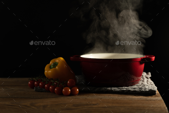 Open cooking pot with hot steam on an old wooden table Stock Photo by ...