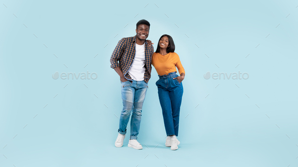 Confident couple standing and posing at blue studio background Stock ...