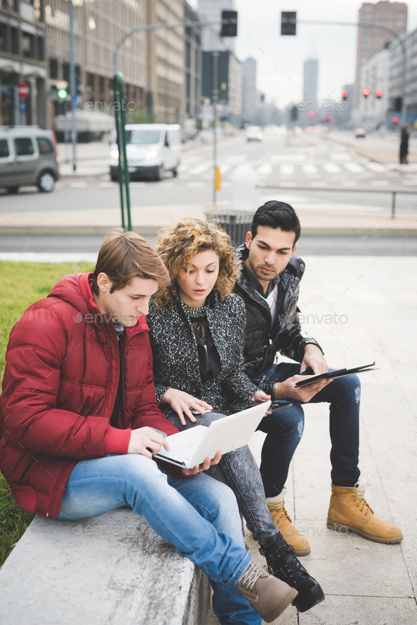 Multiracial business people working outdoor in town Stock Photo by peus80