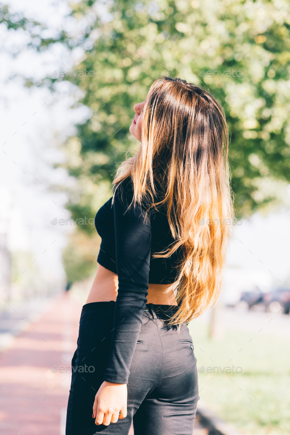 back view young woman outdoor posing looking away Stock Photo by peus80