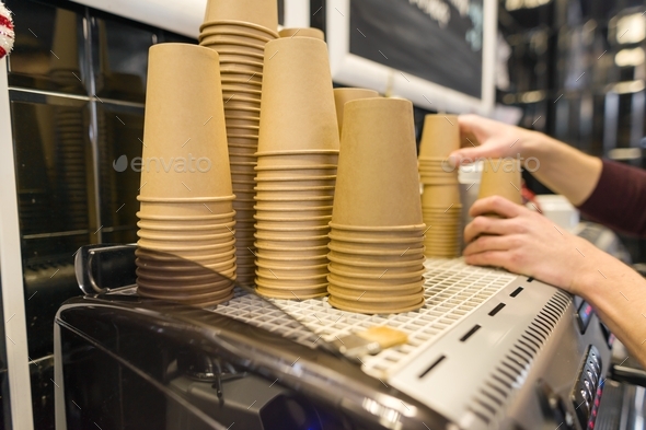 Brown kraft paper coffee cups on coffee machine in coffee shop interior ...