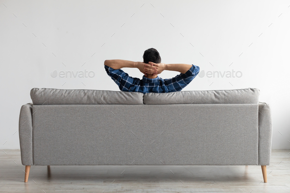 Man having rest at home on the couch Stock Photo by Prostock-studio