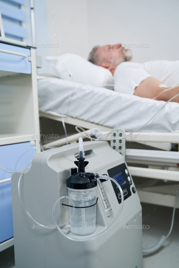 Recumbent male patient connected to portable oxygen concentrator Stock ...