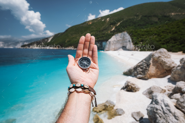 Hand holding a compass on the beach in background Stock Photo by Igor ...