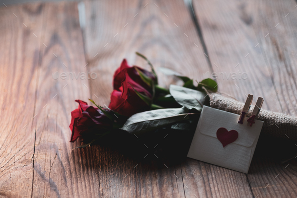 Valentines red roses and card with pegs with number fourteen on wooden ...