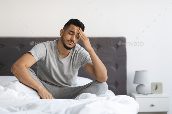 Fatigue Concept. Tired Young Arab Man Sitting In Bed At Home Stock ...
