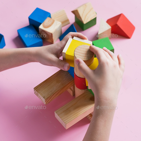 Little kid plays assemble with wooden cubes constructor. Education ...