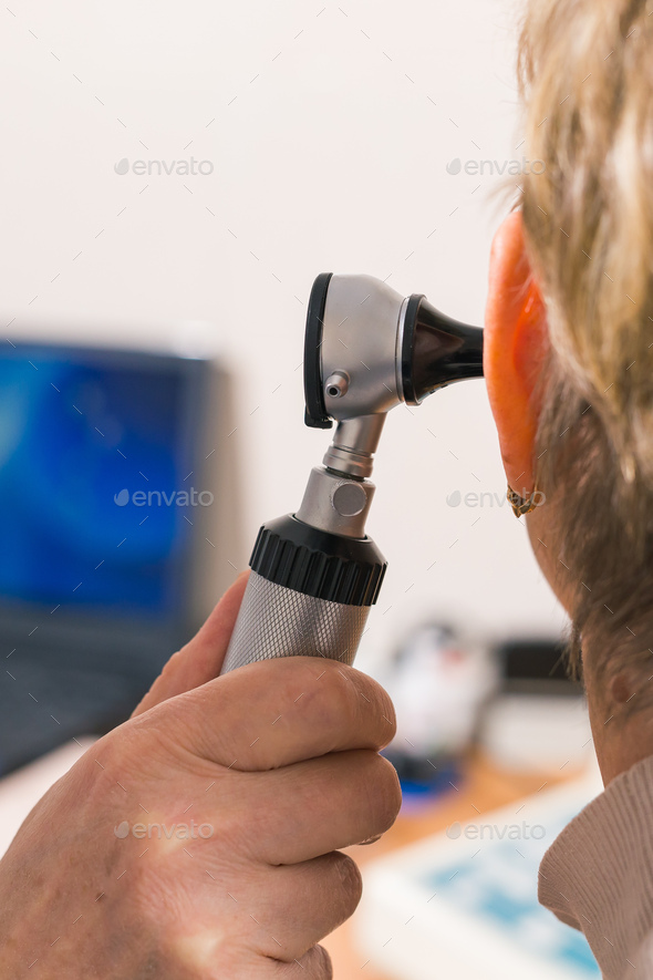 Doctor using otoscope instrument to check womans ear in hospital ...