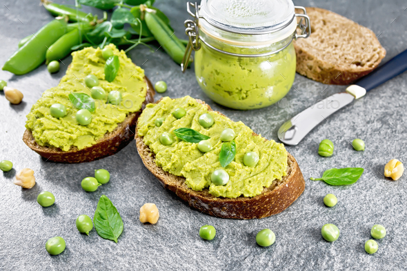 Sandwich green pea hummus on stone dark table Stock Photo by rezkrr