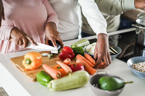 Black family cooking inside kitchen at home - Focus on left hand ...