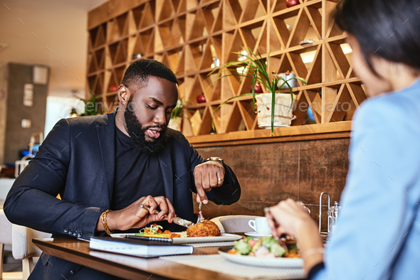 Two colleagues having lunch in company's restaurant. Focus on the man ...