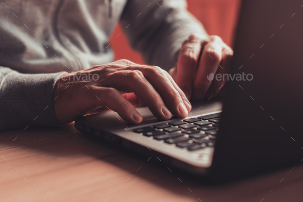 Man typing laptop computer keyboard in home office, closeup of hands ...