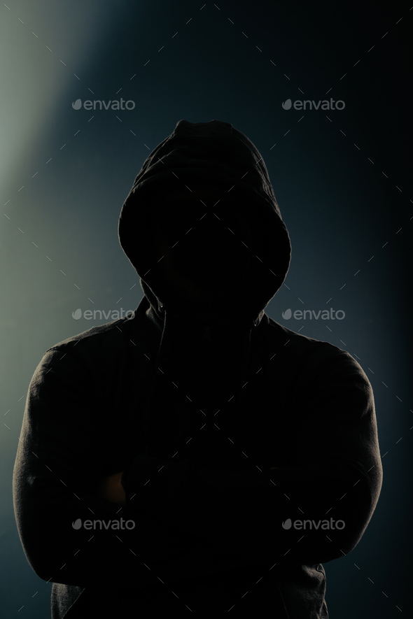 Mystery man with hidden face in a hood in the dark. Stock Photo by ...