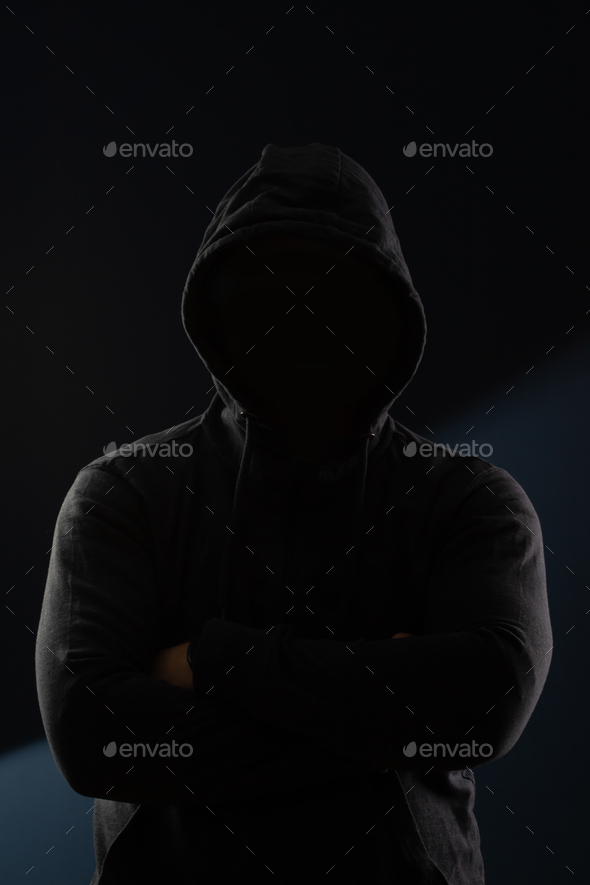 Mystery man with hidden face in a hood in the dark. Stock Photo by ...