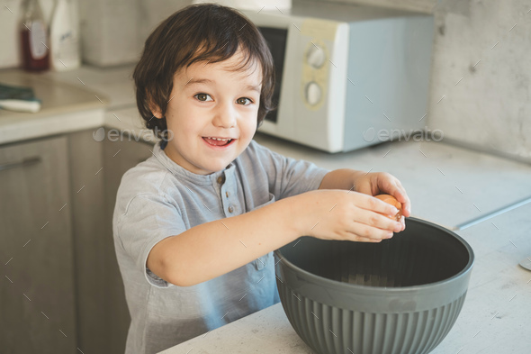 A little boy is cooking in the kitchen Stock Photo by EvgeniiaFreeman