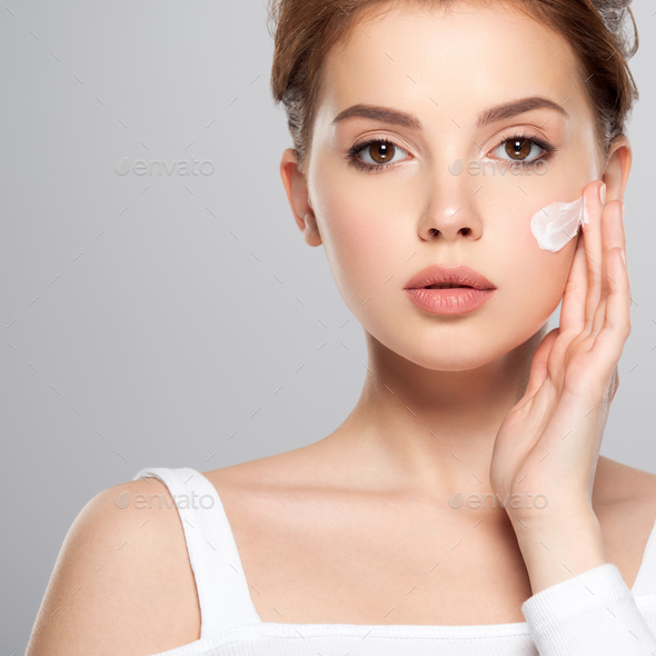 Pretty white model caring of face. Woman applying cream on face. Stock ...