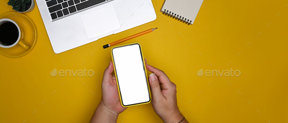 Above view man holding smart phone on yellow background. Stock Photo by ...