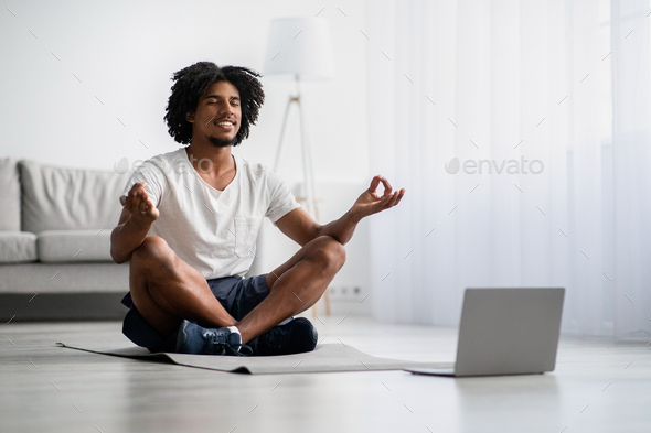 Domestic Yoga. Handsome Black Guy Meditating In Front Of Laptop At Home ...