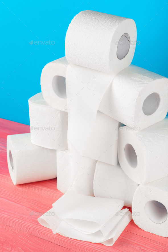 Toilet paper stack on bright blue background Stock Photo by FabrikaPhoto