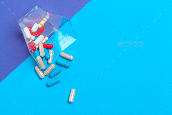 set of multi-colored tablets and capsules on a blue background Stock ...