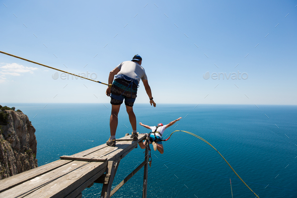 Rope jumping off a cliff with a rope in the water. The ocean. Sea ...