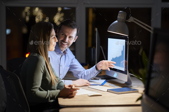 Caucasian woman and man working late together at the office Stock Photo ...
