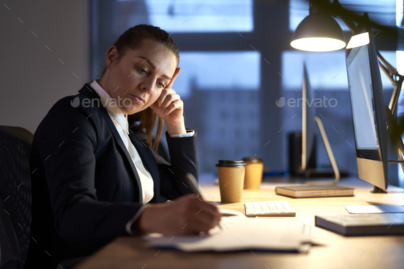 Caucasian adult woman working to late at the office Stock Photo by ...