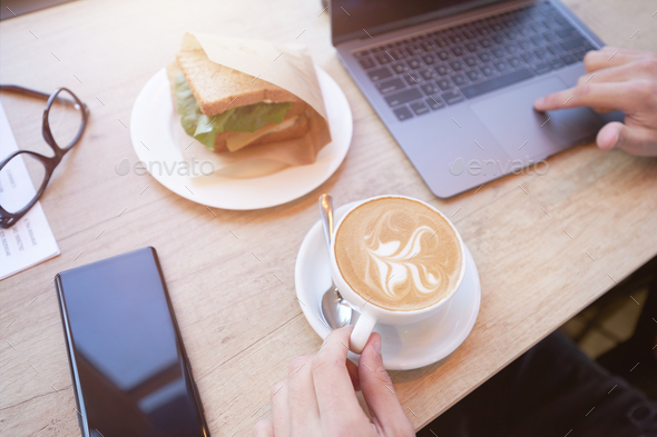 Top view of a freelancer or businessman using laptop, drinking coffee ...