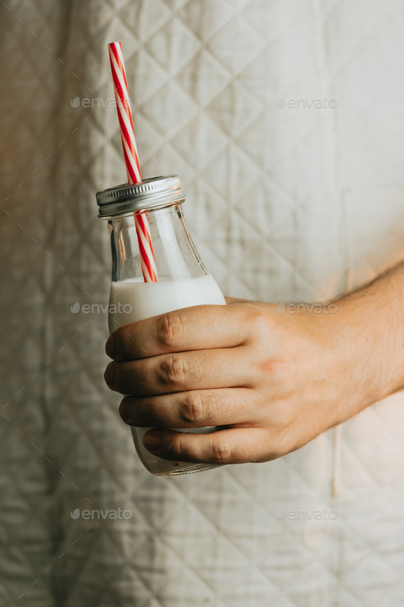 Hand holding a milkshake summer concept with copy space over a dark ...