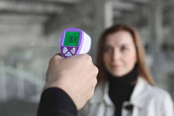 Operator check fever by digital thermometer visitor at information ...