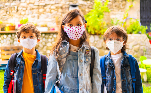 Three brother children with face masks ready for going back to school ...