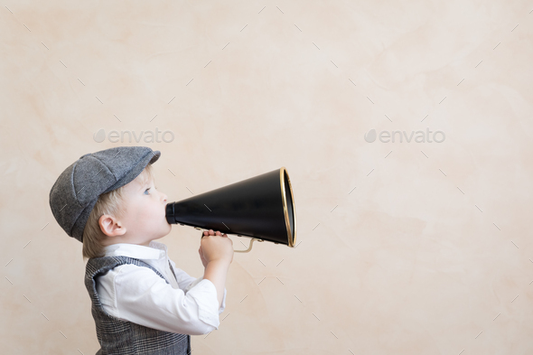 Kid shouting through vintage megaphone Stock Photo by Sunny_studio