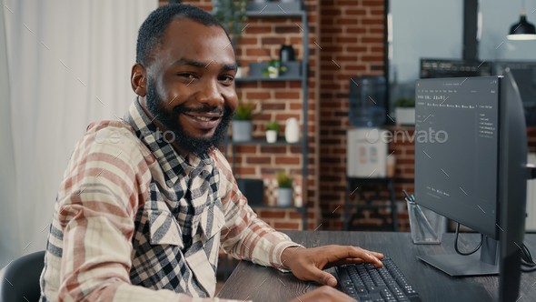 Software developer typing programming code on computer keyboard turning head and smiling Stock ...