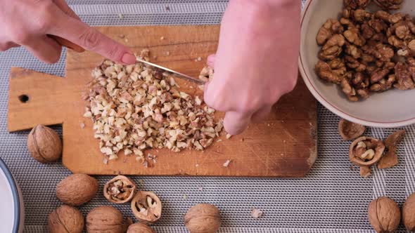 Chopping Walnuts Cores with Kitchen Knife on a Wood Cutting Board ...