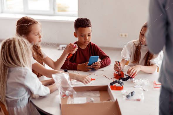 Schoolchildren constructing model with constructor details in school ...
