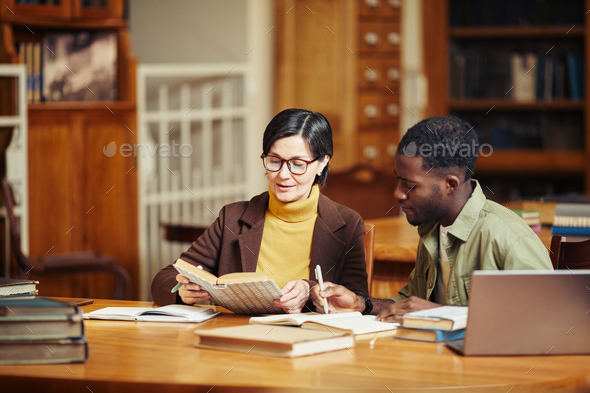 Two People Reading in Library Stock Photo by seventyfourimages | PhotoDune