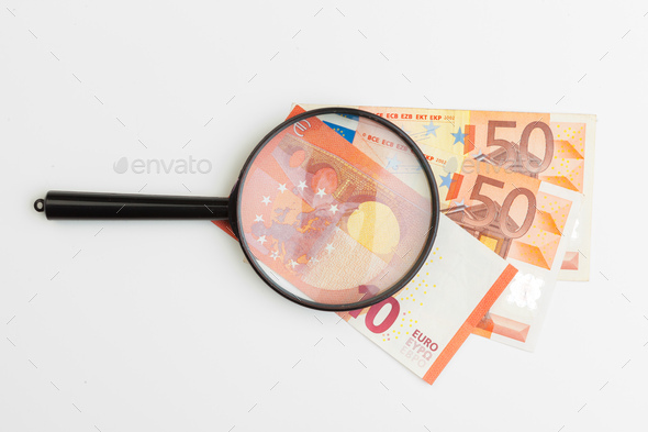 Magnifying glass and a pile of money Stock Photo by FabrikaPhoto ...