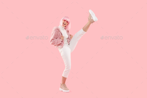 Full length portrait of young energetic woman doing high kick in air ...