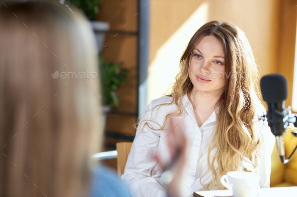 Blogger woman giving interview with microphone in cafe. Stock Photo by ...