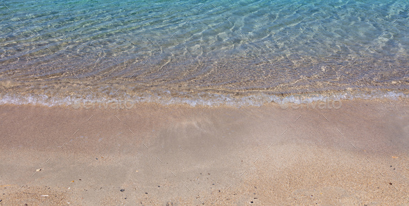Sandy beach, ocean sea water touch wet sand close up. Greece summer ...