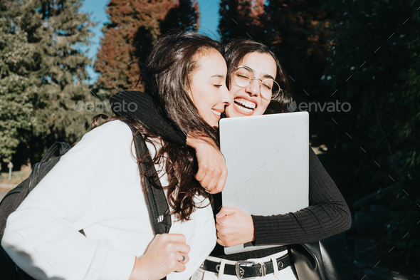Two college students going for their class while talking and having ...