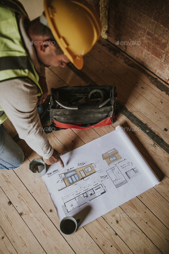 Contractors reading floor plan at a construction site Stock Photo by ...