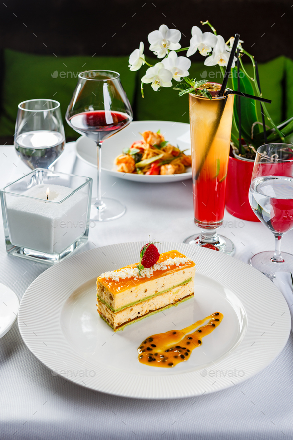 Portion dessert mousse cake with pistachios and passion fruit tropical ...