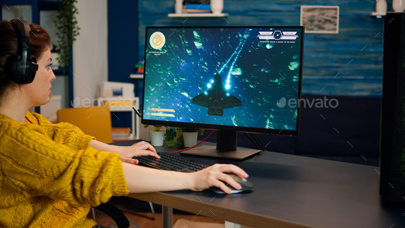 Concentrated gamer playing first-person space shooter game Stock Photo ...