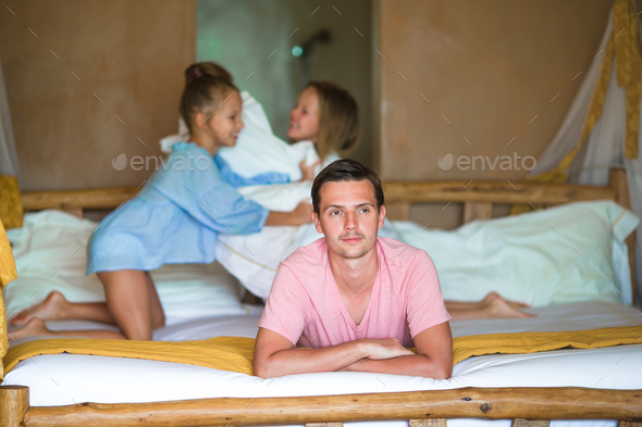 Father with two adorable little girls having fun in bed Stock Photo by ...